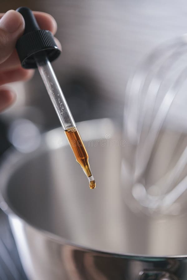 Pipette with Vanilla Extract Close-up in Hand with Soft Focus Against ...