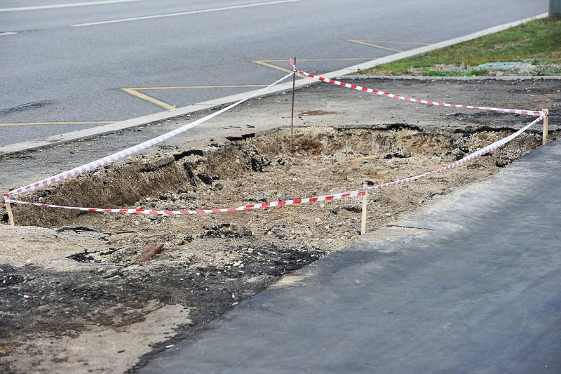 A Pit on the Road, Fenced with a Red Ribbon - Road Works Stock Photo ...