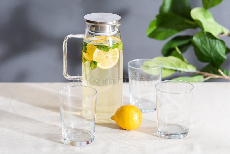 Pitcher of Clear, Refreshing Water Surrounded by Several Glasses Filled ...