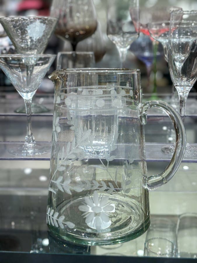 A Pitcher with a Floral Design Sits on a Table Next To a Variety of ...