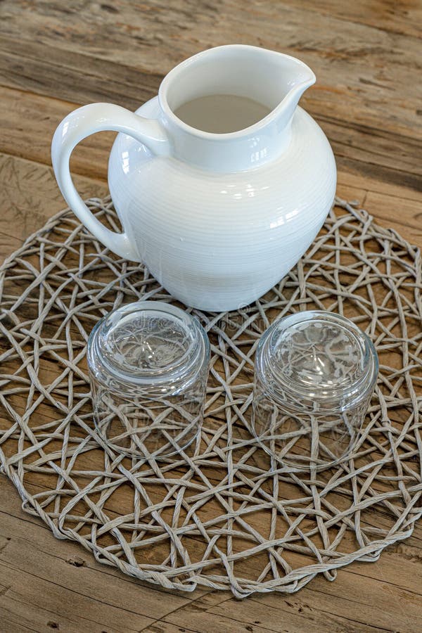 A Pitcher and Two Glasses are on a Table Stock Photo - Image of white ...