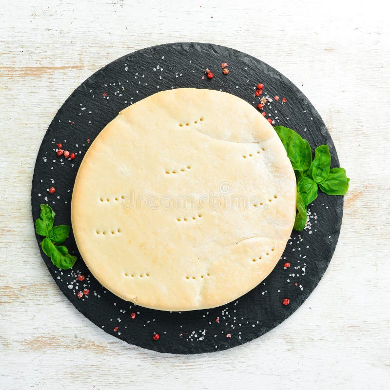 Pizza Base on a Black Stone Plate with Basil. Stock Image - Image of ...