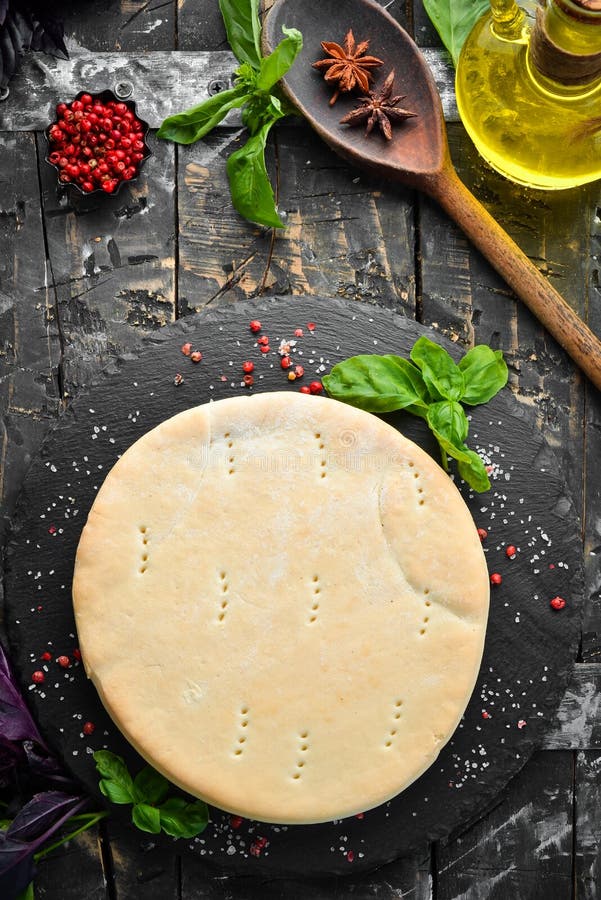 Pizza Base on a Black Stone Plate with Basil. Stock Image - Image of ...