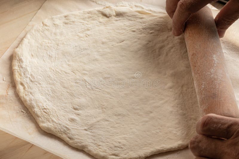 Pizza Dough Being Rolled Out by a Man. Process of Making Pizza Stock ...
