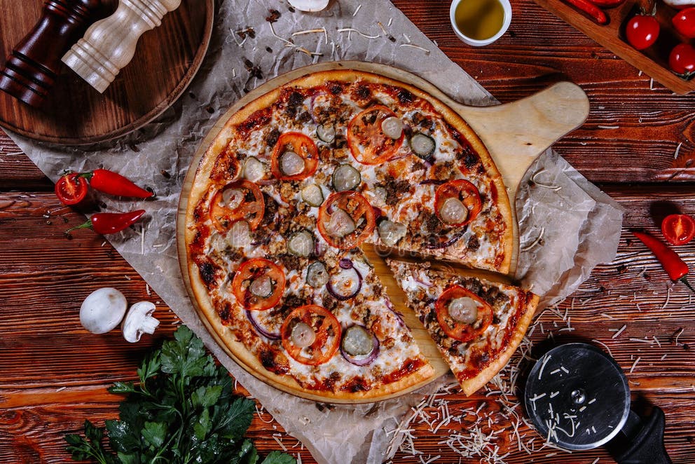 The Pizza is on the Kitchen Table, and the Ingredients are Scattered ...