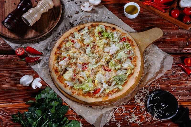 The Pizza is on the Kitchen Table, and the Ingredients are Scattered ...