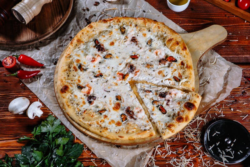 The Pizza is on the Kitchen Table, and the Ingredients are Scattered ...