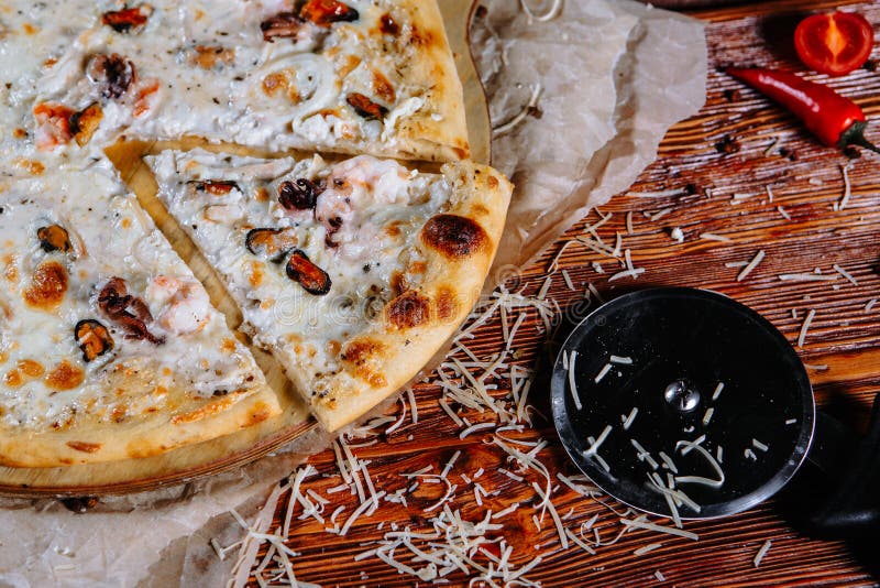 The Pizza is on the Kitchen Table, and the Ingredients are Scattered ...