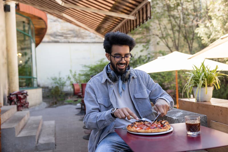 Man Sitting at the Table in a Cafe Cutting Pizza Stock Photo - Image of ...