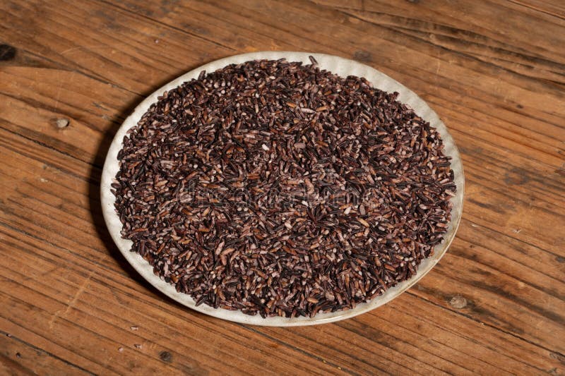 Place the Black Rice in the Plate or Bowl on the Wood Grain Table Stock ...