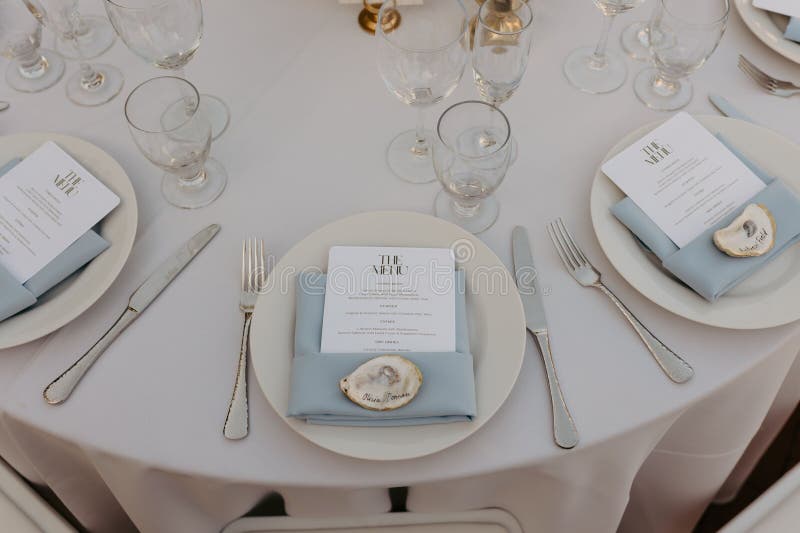 Place Setting on a Round Table Featuring a White Plate, Blue Napkin ...