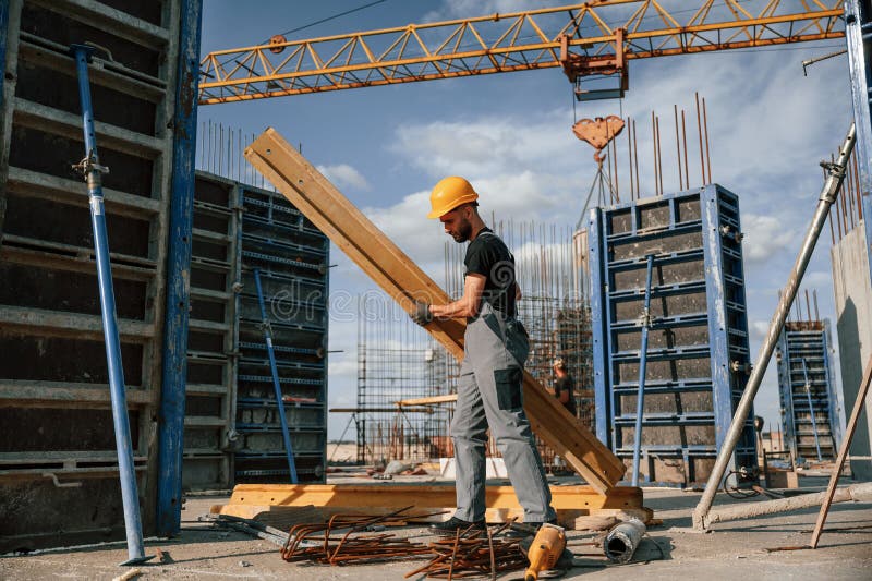 Placing Wooden Plank on the Floor. Man in Uniform is Working on the ...
