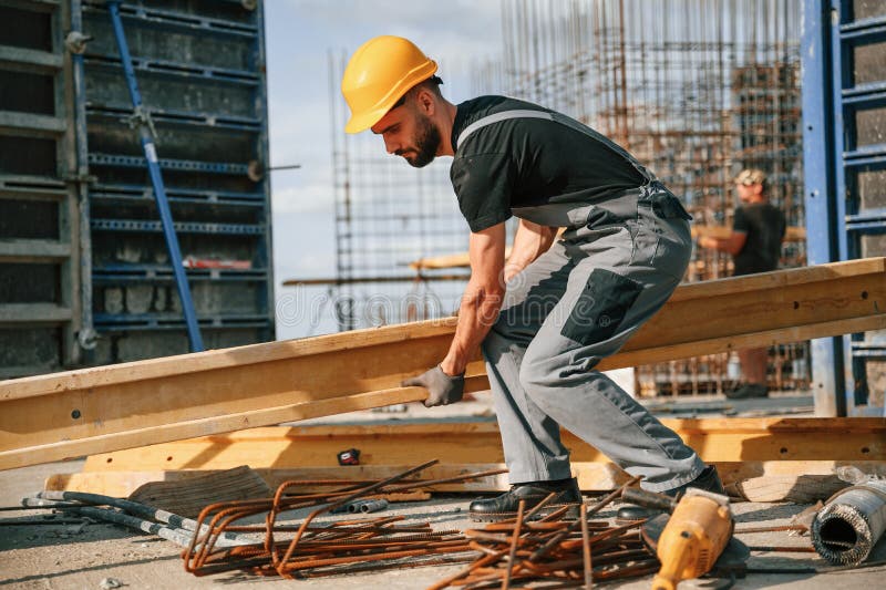 Placing Wooden Plank on the Floor. Man in Uniform is Working on the ...