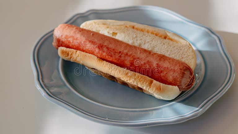 Plain Hot Dog in a Bun on a Blue Plate Stock Photo - Image of unadorned ...