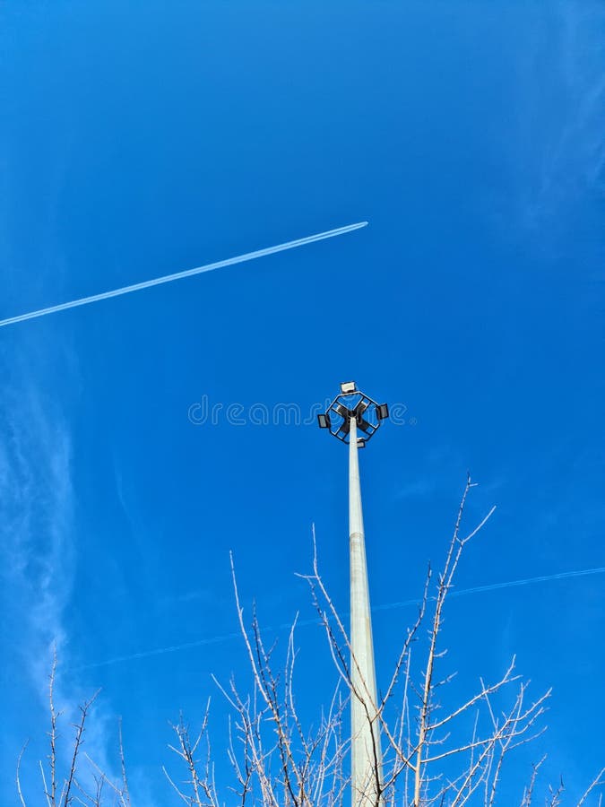 Plain, Light Pole, Tree and the Sky Stock Photo - Image of cloud, mast ...