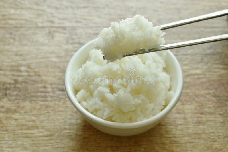 Plain Rice Scooping in Silver Chopticks on Cup Stock Photo - Image of ...