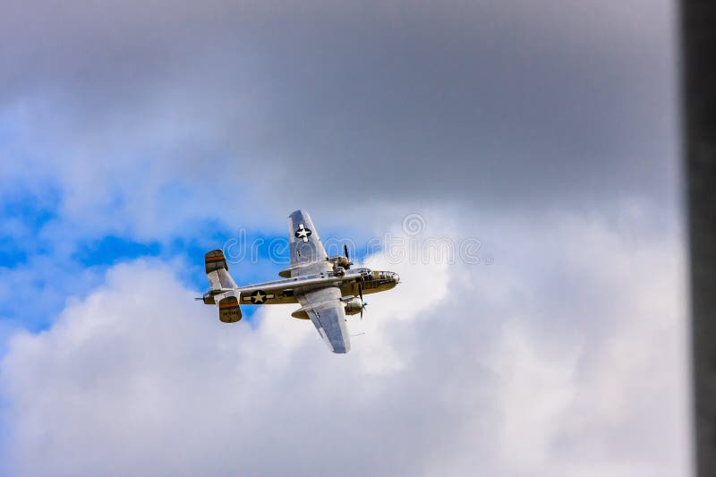 A Plane with a Cross on the Tail Flies through a Cloudy Sky Stock Image ...