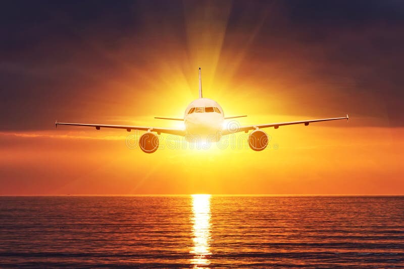 The Plane Flies in Front of the Sun. Sunset Over the Sea, View of the ...