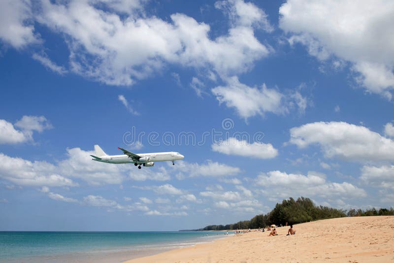 A Plane Flies Over the Beach with People on a Sunny Day Stock Image ...