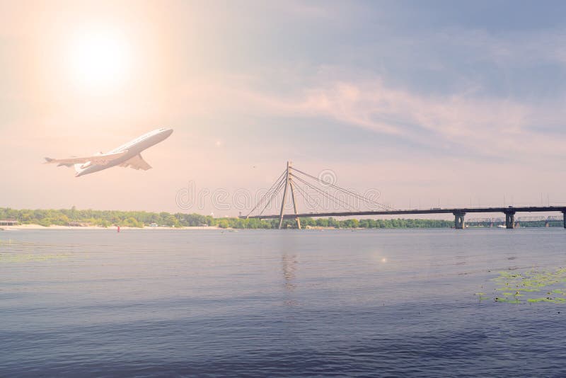 The Plane Flies Over the River and the Bridge Stock Image - Image of ...
