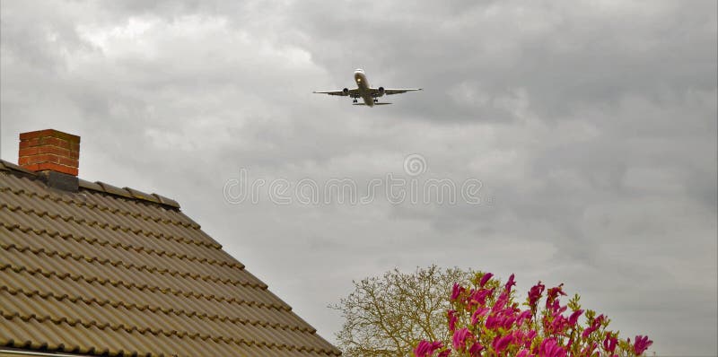 Plane Flies Over the Rooftops Stock Image - Image of clouds, roof: 70778797