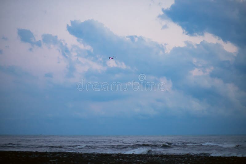 Plane Flies in the Sky Over the Sea in the Late Evening Stock Photo ...