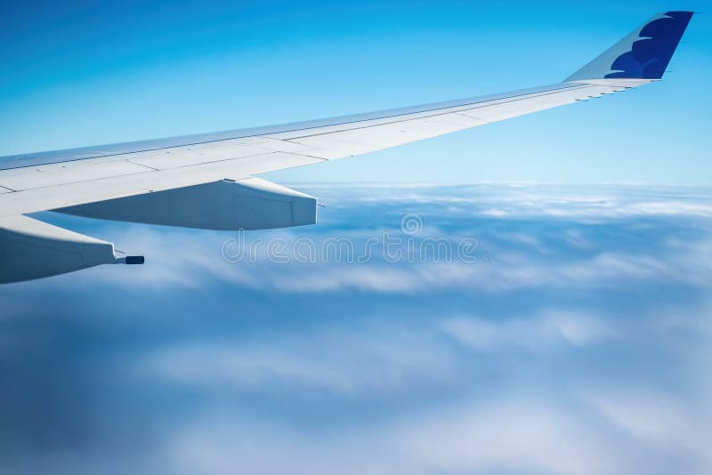 Plane flying above clouds stock photo. Image of wing - 65057650