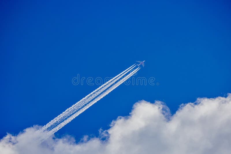 A Plane Flying through a Blue Cloudy Sky Stock Photo - Image of tourism ...