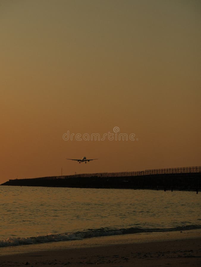 A Plane is Flying Over a Beach at Sunset Stock Image - Image of beach ...