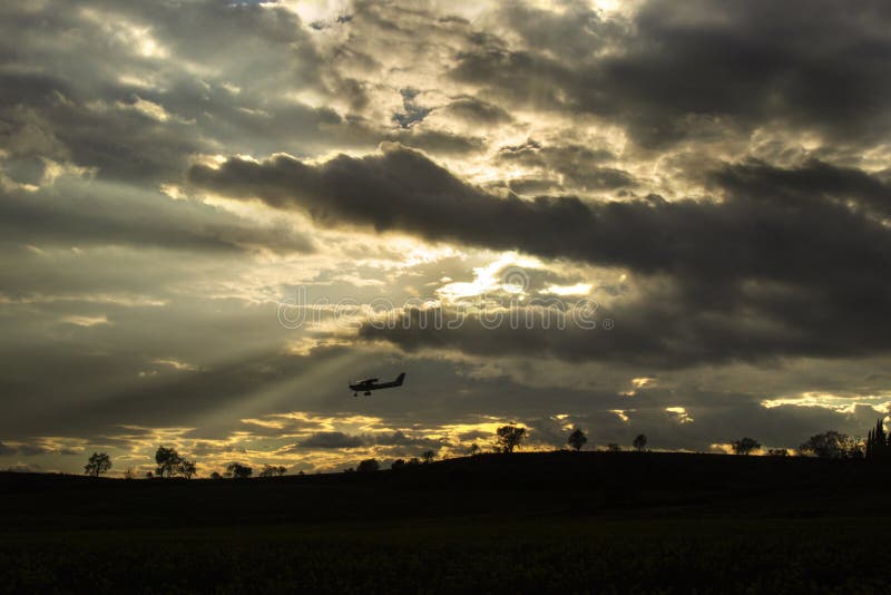 Plane flying over a field stock image. Image of silhouettes - 195119717