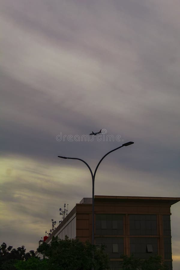 A Plane Flying Right Above a Lamppost Stock Image - Image of flying ...