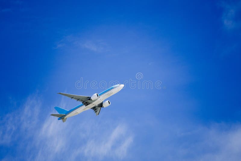 A Blue and White Plane Flying with a Sunny Blue Sky Stock Image - Image ...