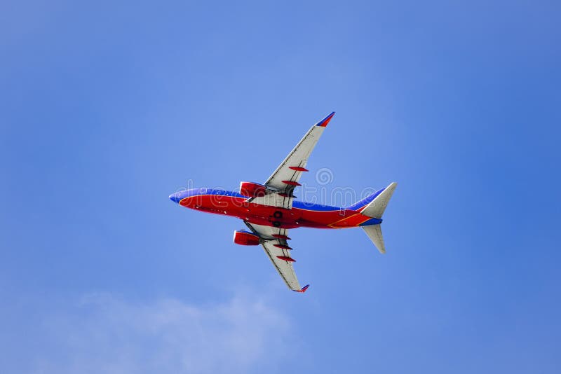 A Red Blue and White Plane Flying with a Sunny Blue Sky Stock Photo ...