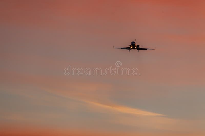 Plane landing in red sky stock photo. Image of cloud - 363170398