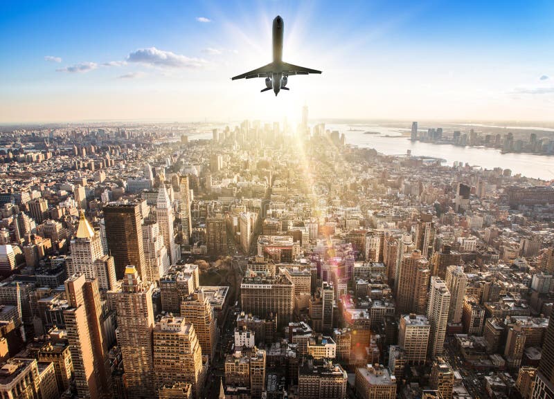 A Plane Flying Over Modern Buildings Of New York City Stock Photo ...