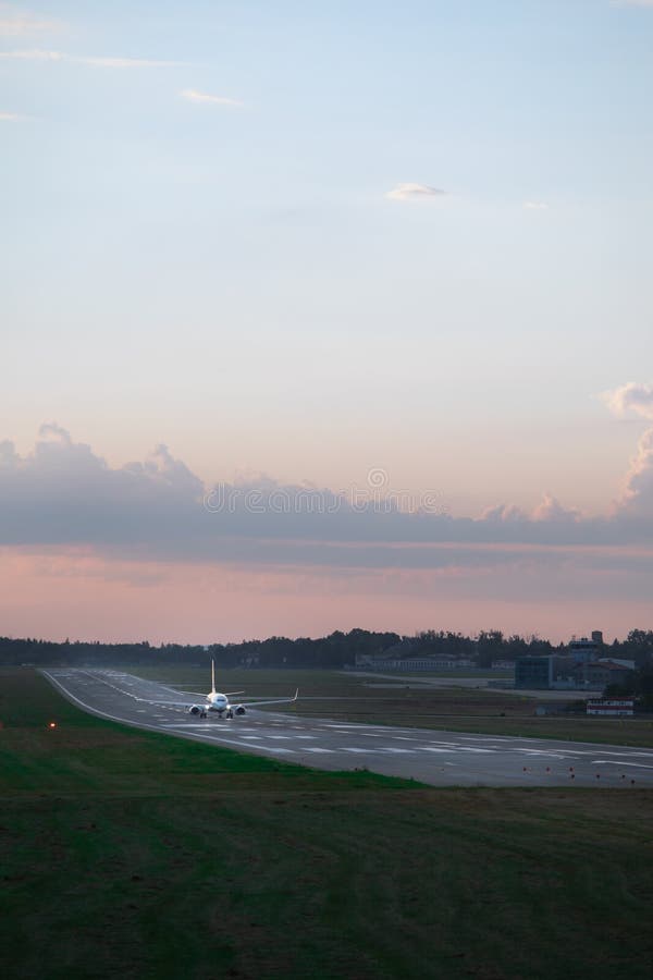 Plane on runway on sunset stock image. Image of wind - 211841951