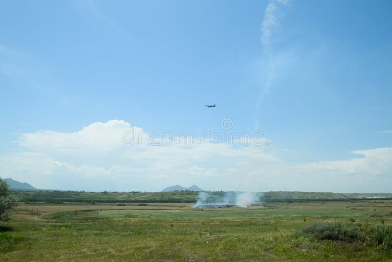 Plane Sets Up, Flying Over the Field Where the Dry Grass Burns Stock ...