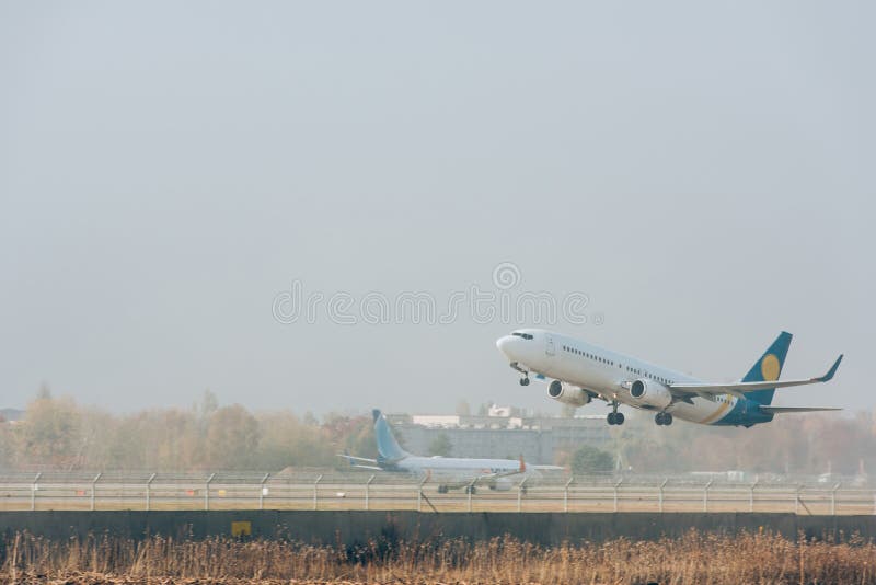 Plane Taking Off from Airport Runway with Cloudy Sky at Background ...