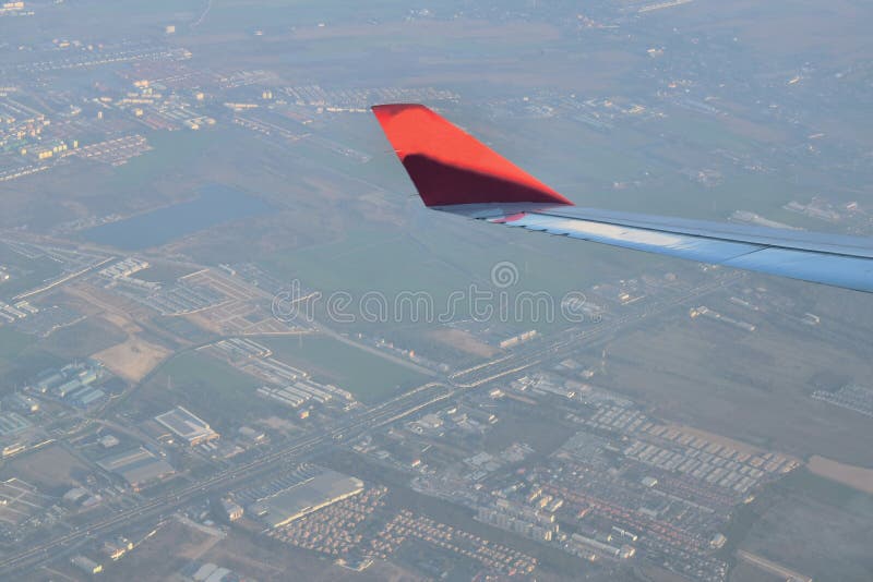 Plane Wing through Window Frame and City View on Ground Stock Photo ...