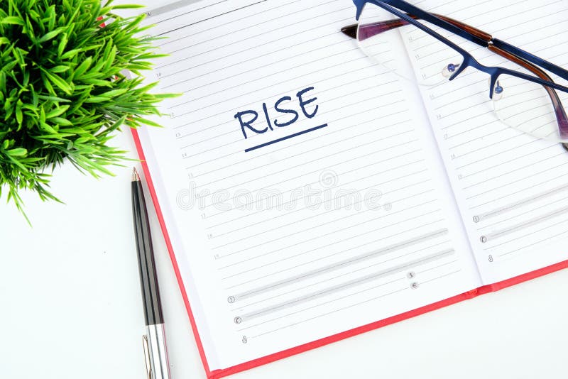 A daily Planner Rests Open on a White Desk, Featuring the Word RISE ...