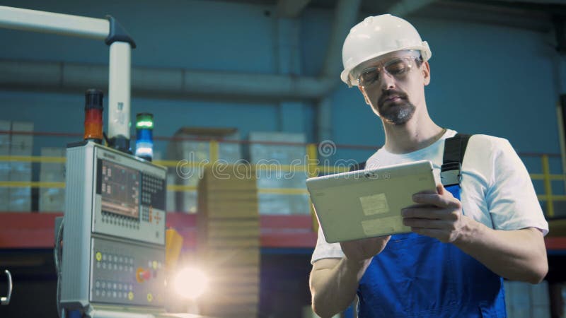 Plant Worker Types on a Tablet, Standing in a Facility Room. Stock ...
