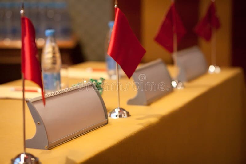 A Plaque with the Name and the Flag on the Table at the Conference ...