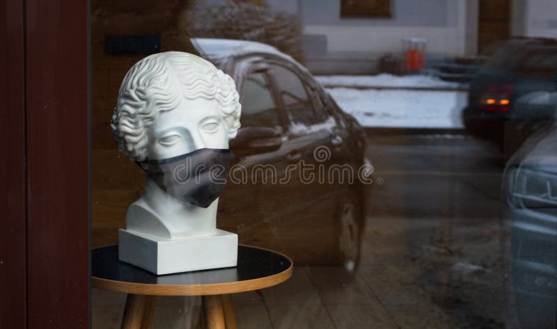 A Plaster Head of Aphrodite in a Black Protective Mask Behind a Glass ...
