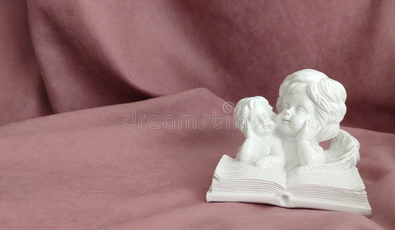 Plaster Statuette of Two White Angels Reading a Large Book Stock Photo ...