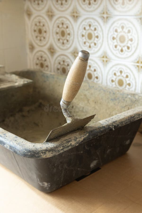 A Plaster Trowel Rests in a Cement Tray Against a Backdrop of Vintage ...