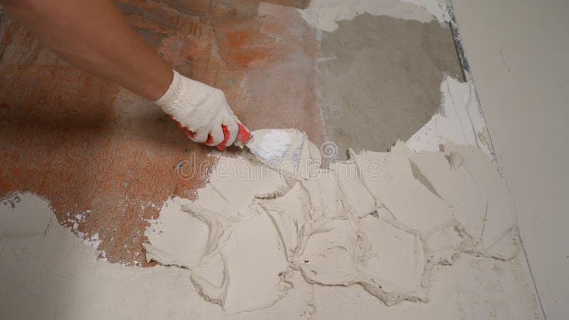 A Worker Applies Plaster To a Wall with a Spatula. White Solution ...