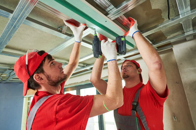 Plasterboard Ceiling Installation. Two Workers Installing Gypsum ...