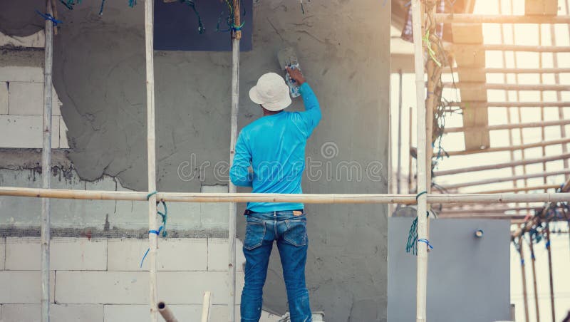 Plasterer in Blue Working Uniform Plastering the Wall of House Building ...