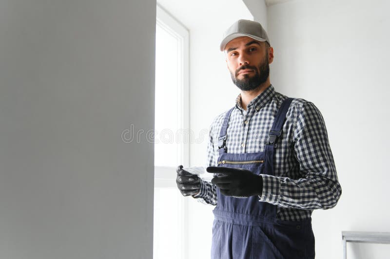 Plasterer in Blue Working Uniform Plastering the Wall Indoors Stock ...