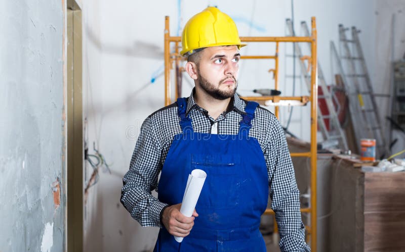 Plasterer is Looking on the Project of Work for the Object. Stock Image ...
